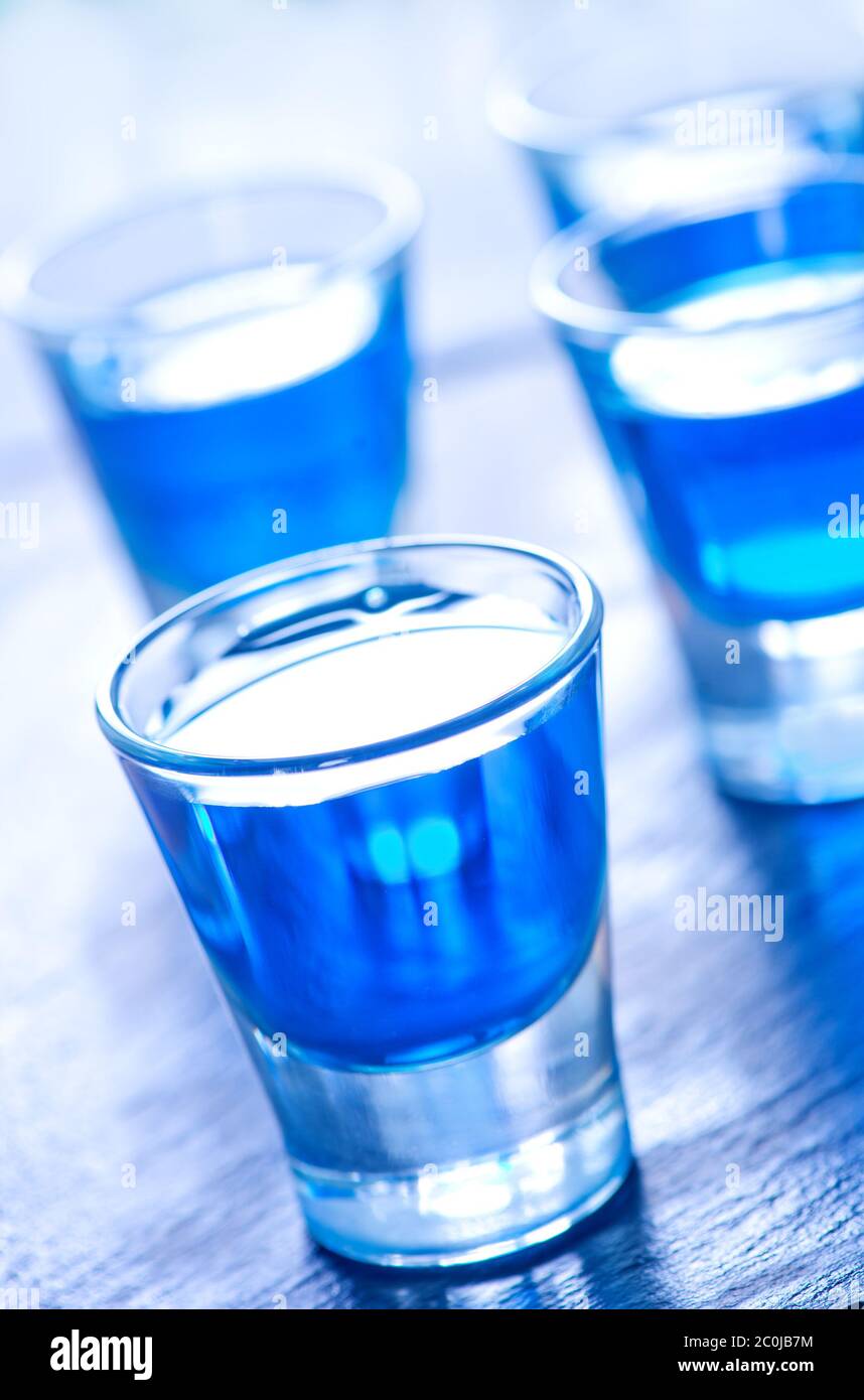 blue alcoholic drink into small glasses Stock Photo - Alamy