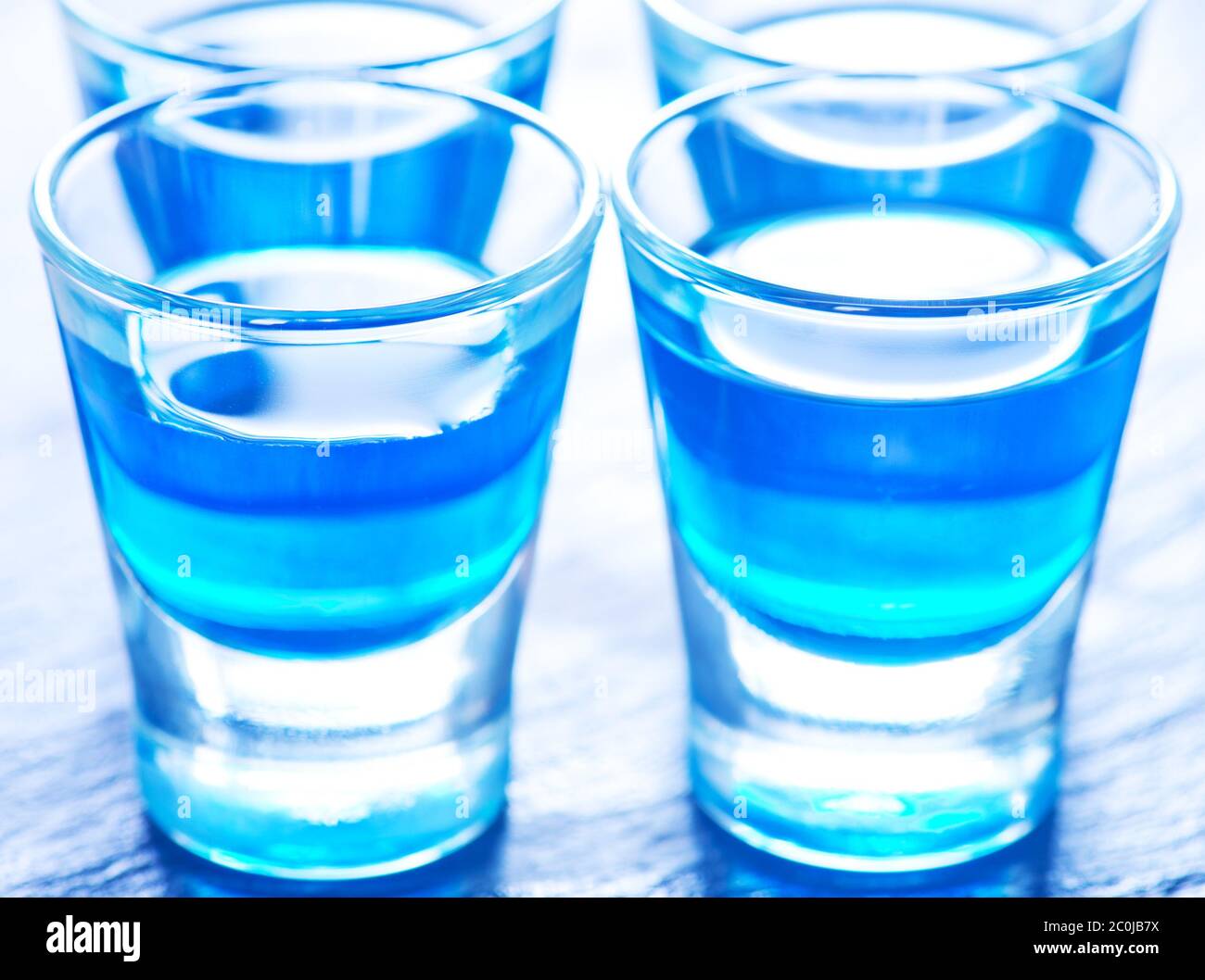 blue alcoholic drink into small glasses Stock Photo - Alamy