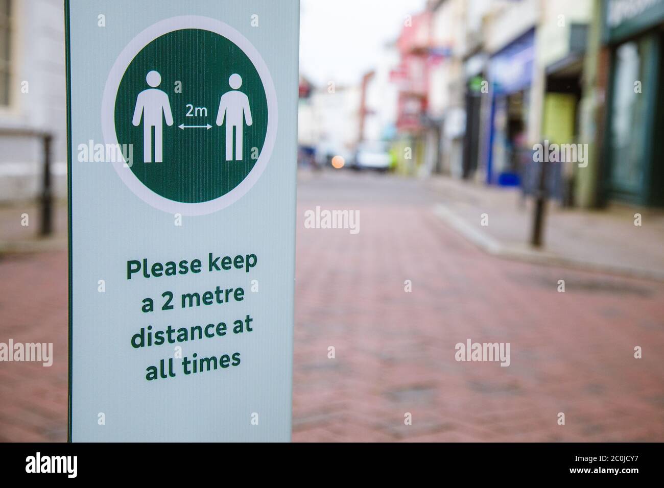 Please keep a 2 metre distance at all times sign. On the high street ...
