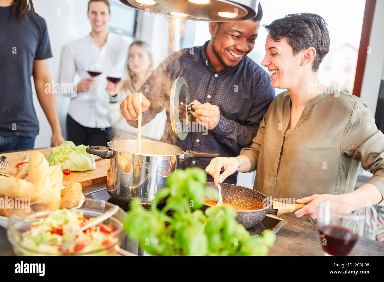 Friends cook pasta with tomato sauce in shared kitchen together for ...