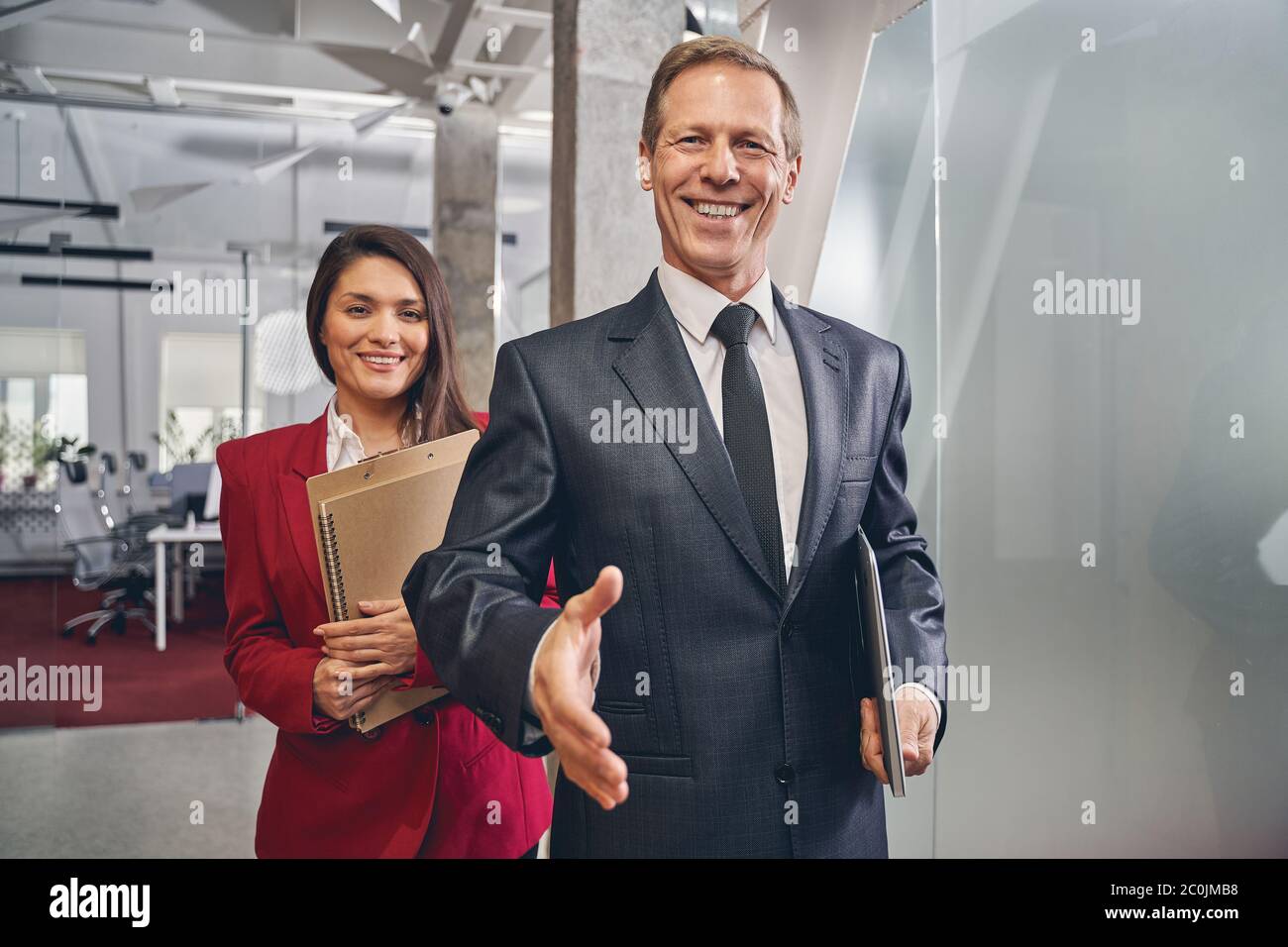 Kind senior man welcoming new business partner Stock Photo - Alamy
