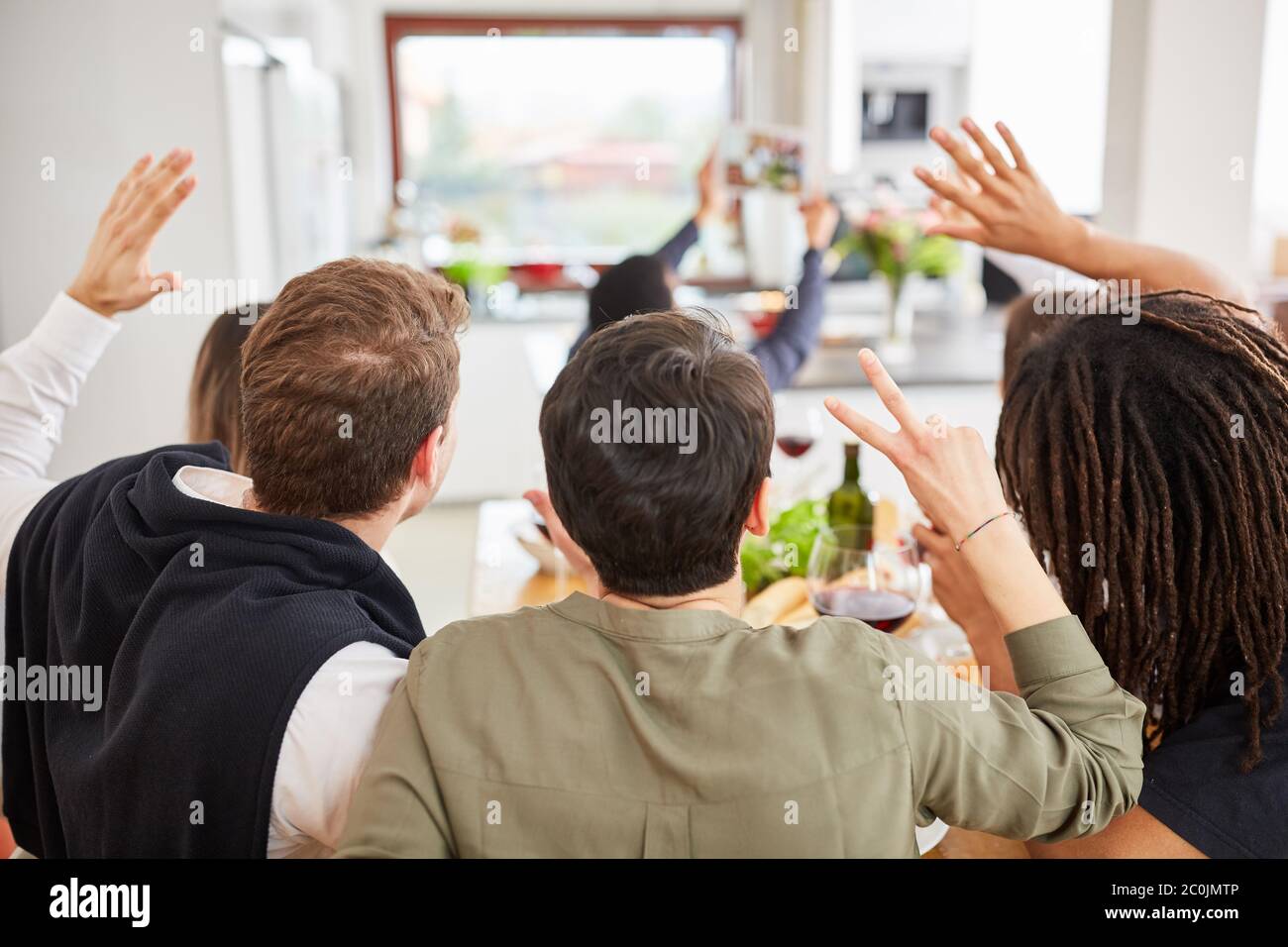Friends at the table eating hand signals and greetings for a video call ...