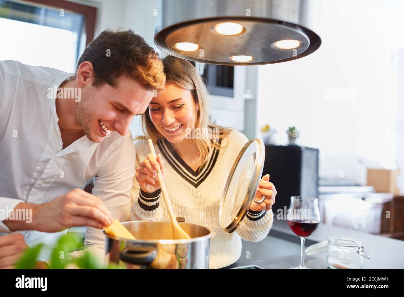 Happy friends together prepare spaghetti pasta in kitchen for lunch ...