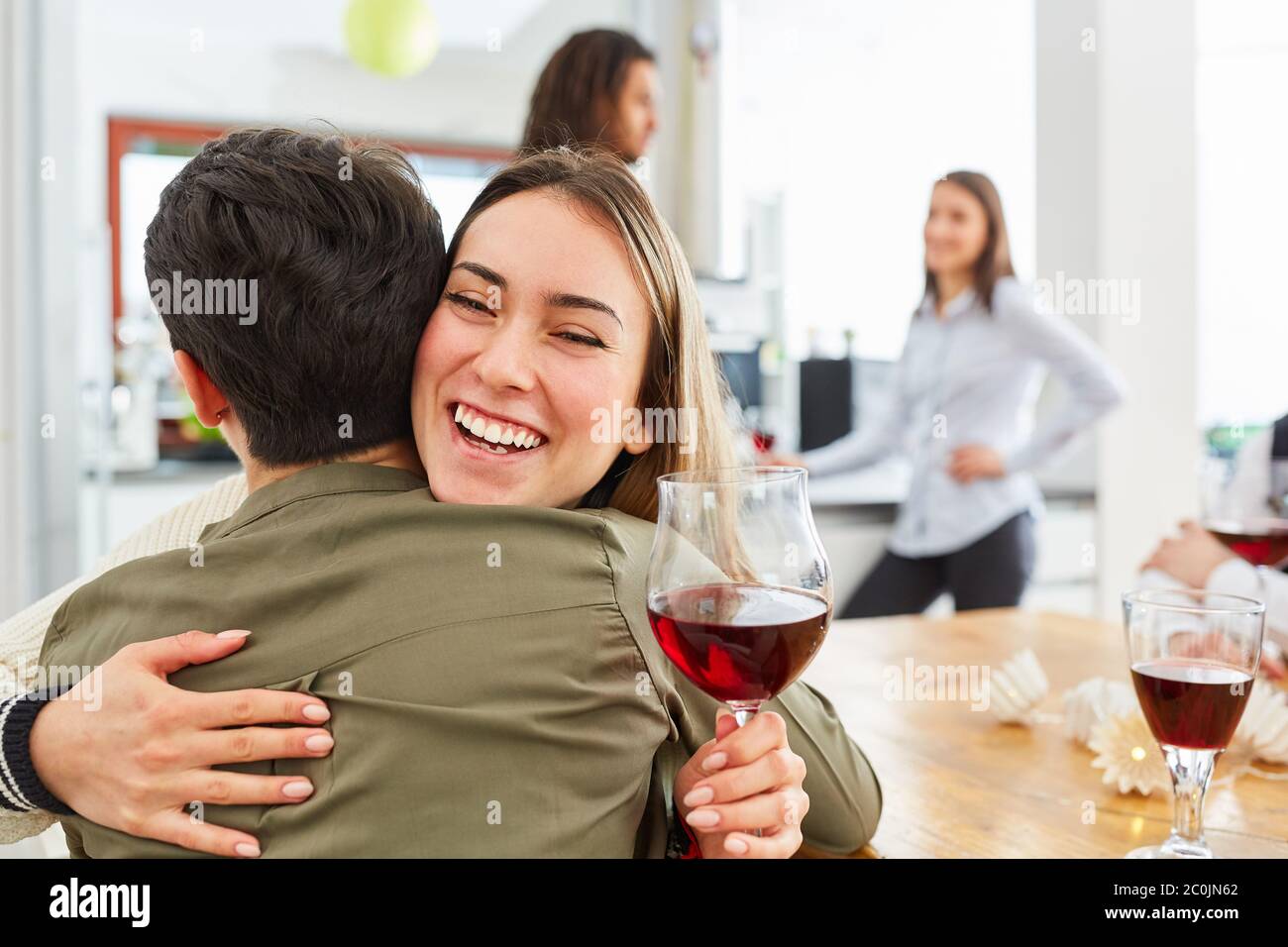 Two women as friends hug for joy at a celebration in the kitchen Stock ...