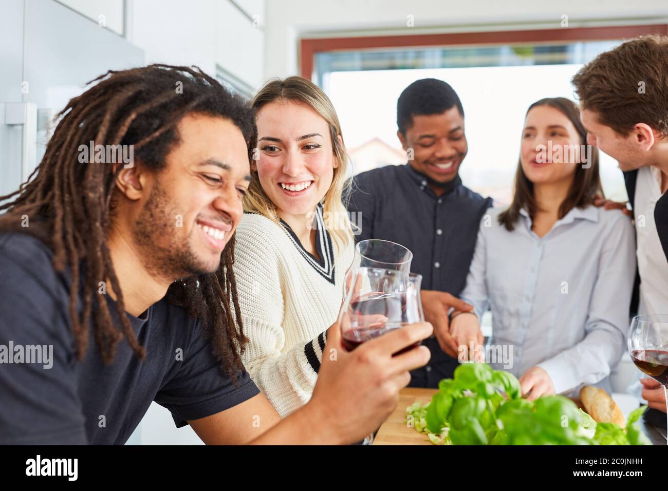 Student friends talking to each other in shared kitchen preparing to ...