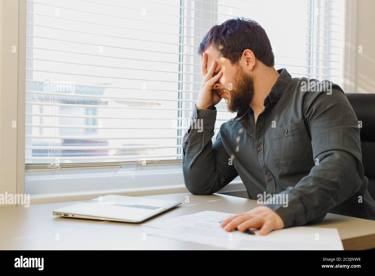 Tired thinking businessman working with documents at office, closed ...