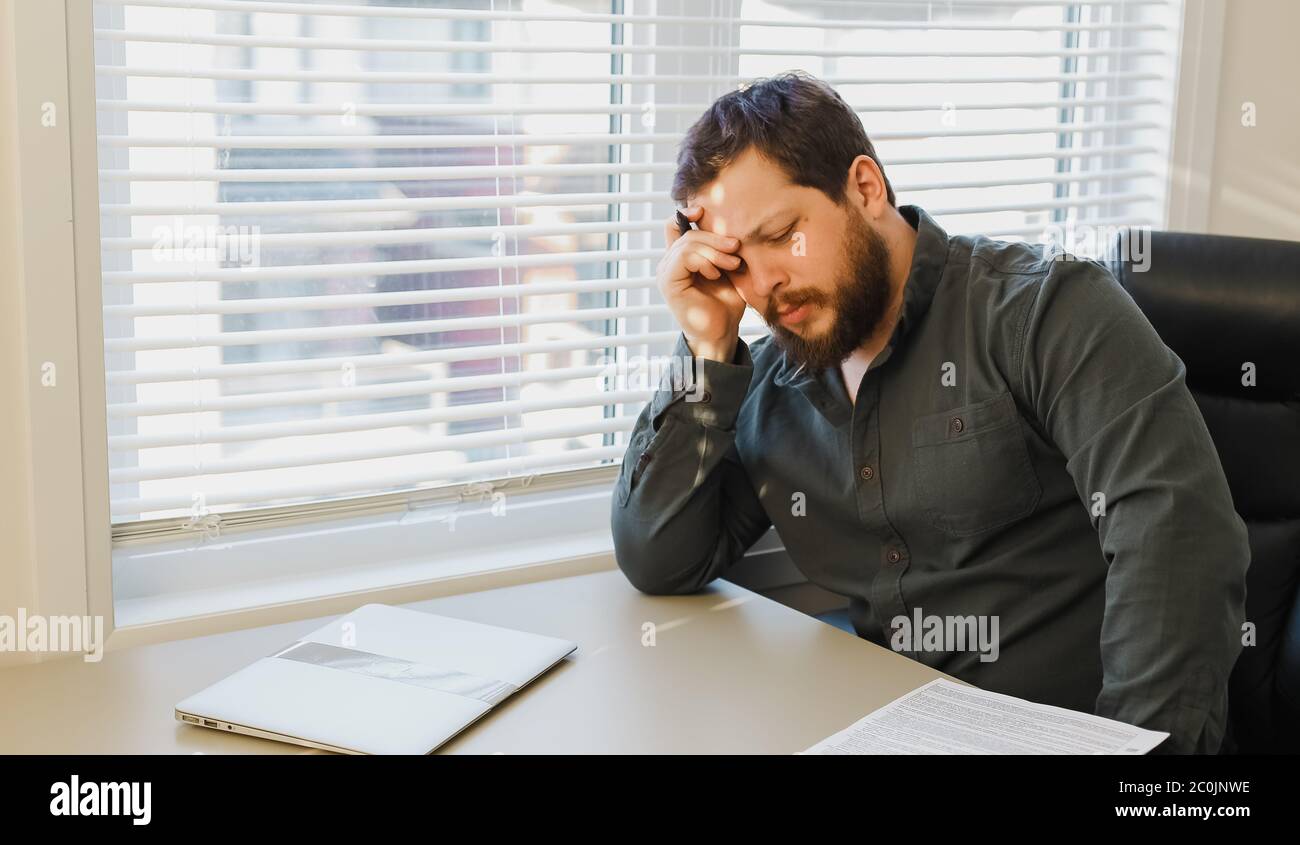 Sad thinking businessman working with documents at office, closed ...