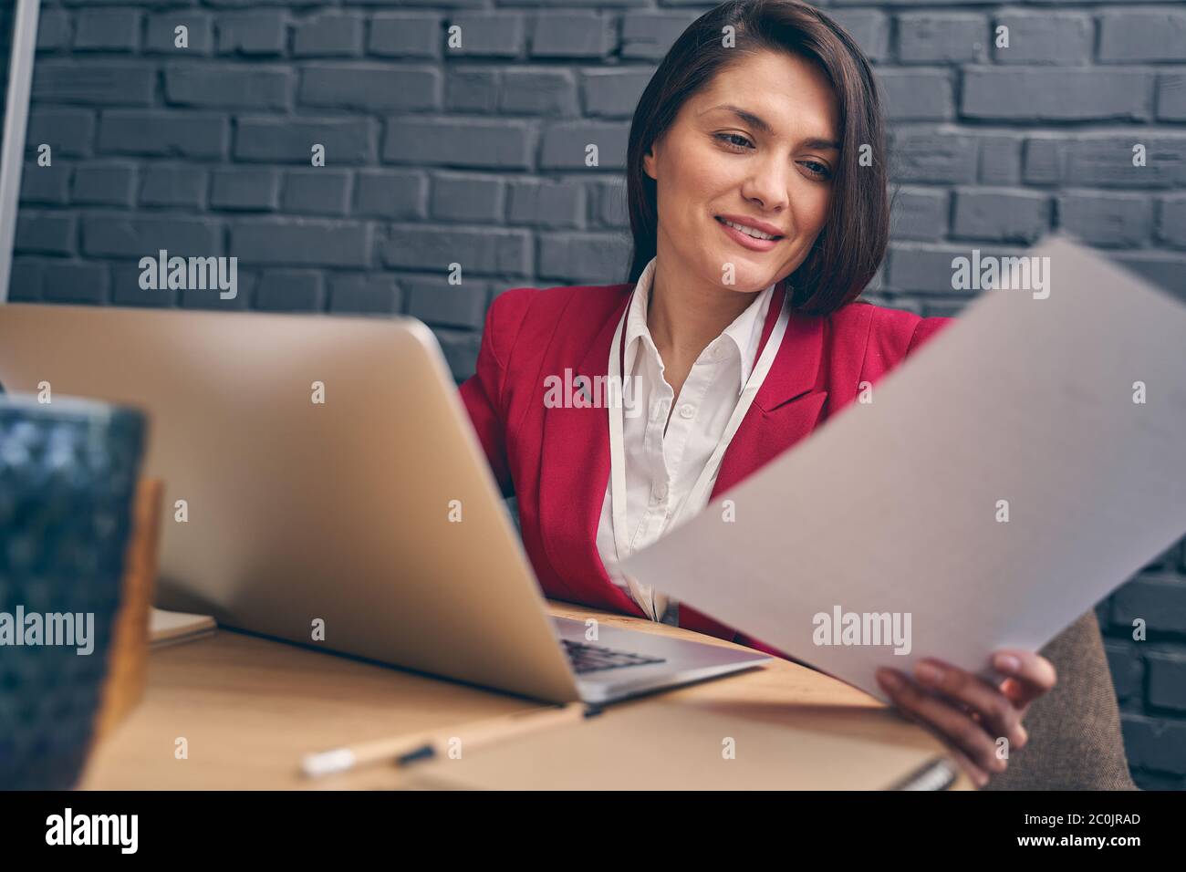 Charming young female person looking at her documents Stock Photo - Alamy