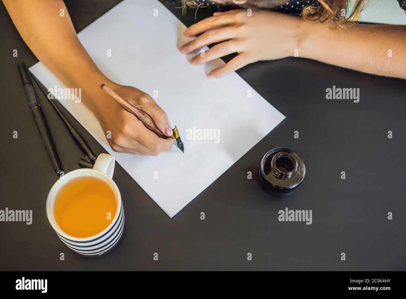 MOCKUP, SCENE CREATOR Calligrapher Young Woman writes phrase on white ...
