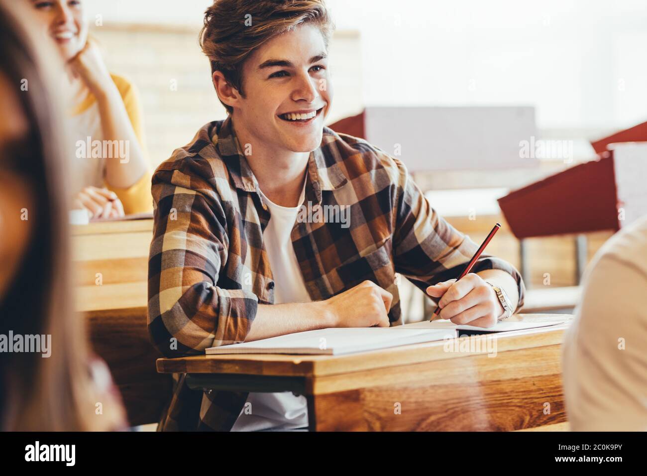 Teenage boy smiling during lecture in high school classroom. Male ...