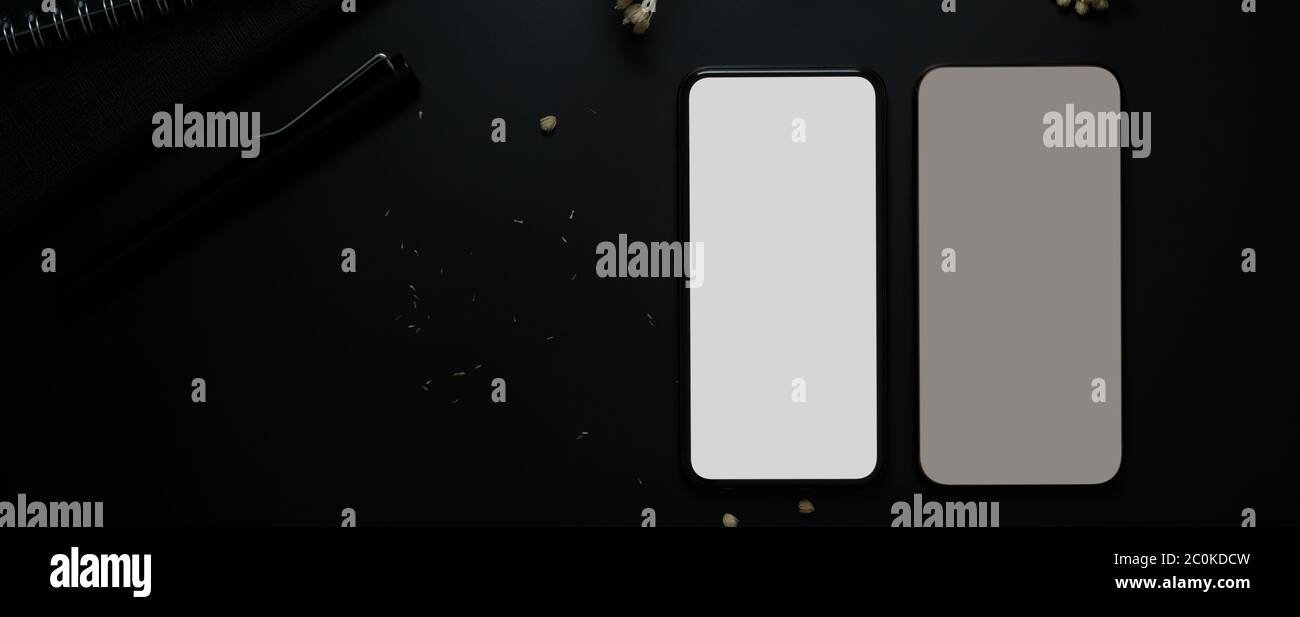Top view of front and back of smartphone and stationery on dark modern ...