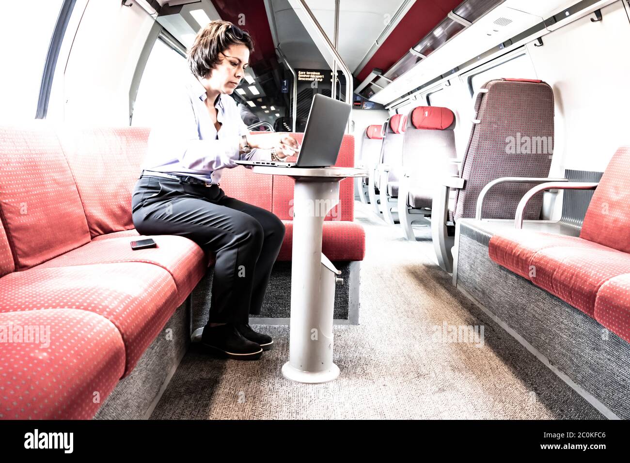 Business Woman Working on Laptop and Smartphone in First Class in a ...