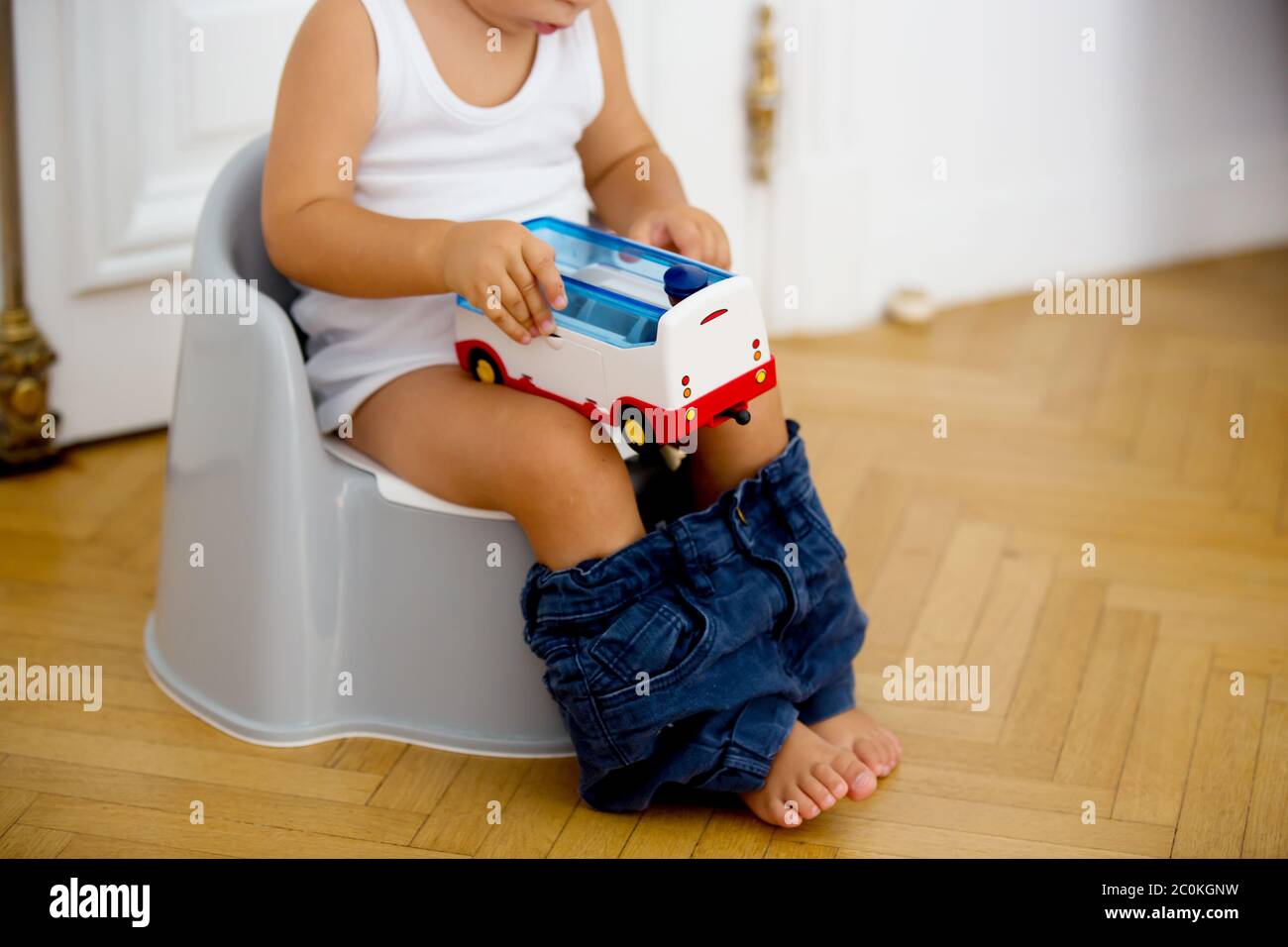Infant child baby boy toddler sitting on potty, playing with toys in ...