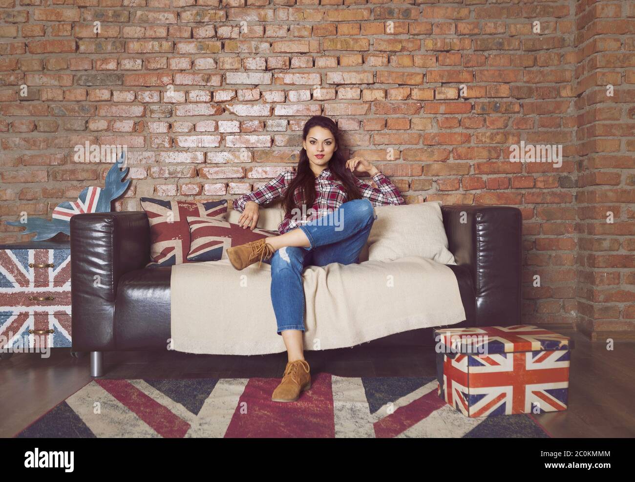 Pretty hipster girl sitting on couch at home Stock Photo - Alamy