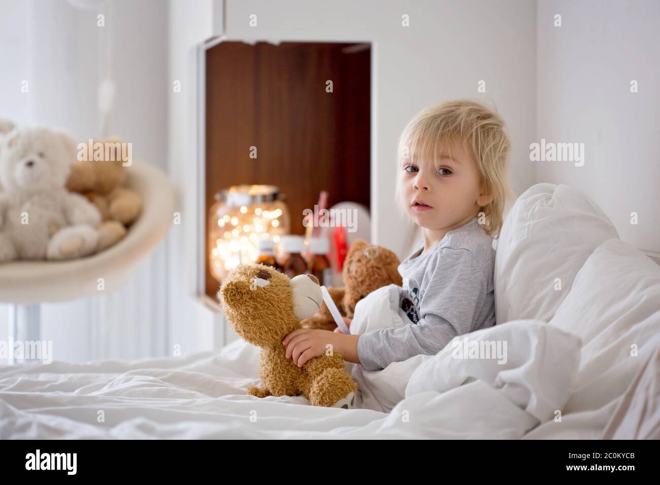 Sick child, toddler boy lying in bed with a fever, resting Stock Photo ...