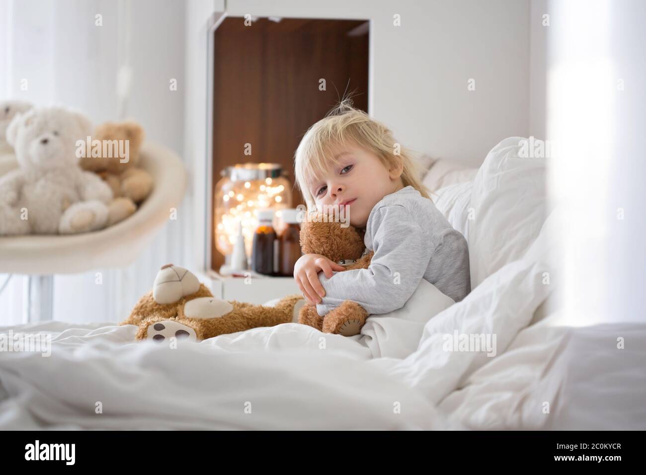 Sick child, toddler boy lying in bed with a fever, resting Stock Photo ...