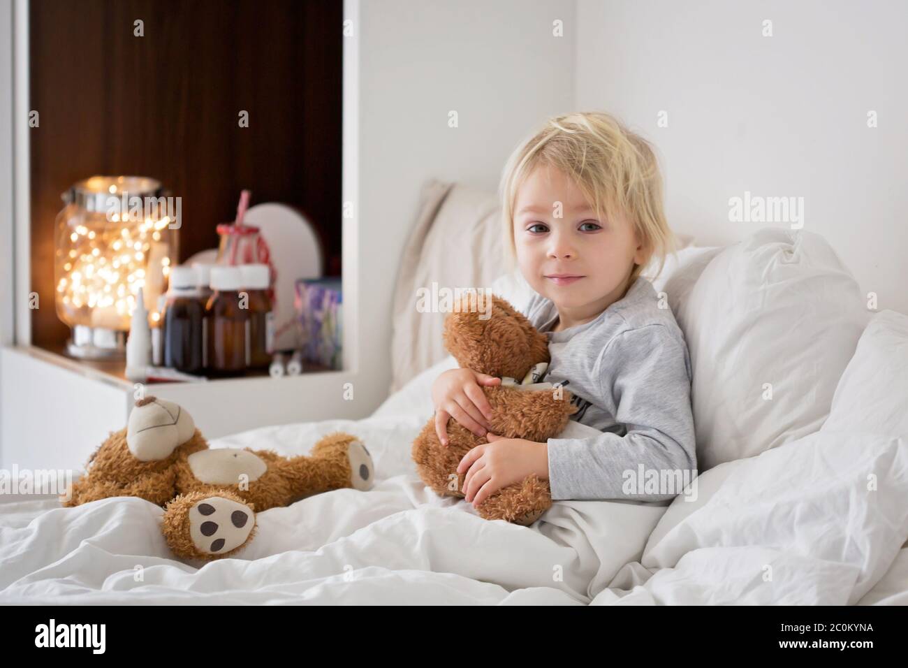 Sick child, toddler boy lying in bed with a fever, resting Stock Photo ...