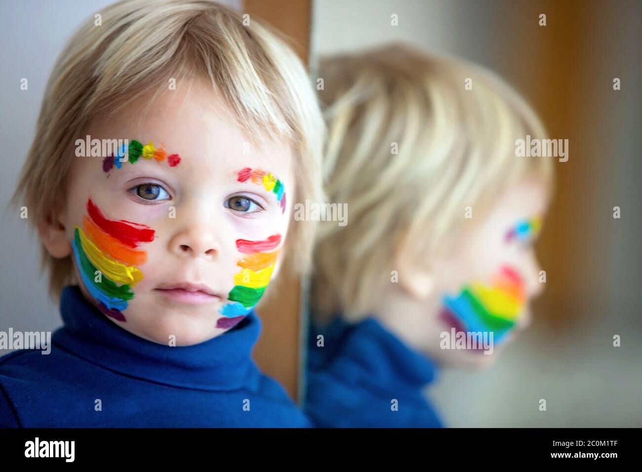 Beautiful blond toddler boy with rainbow painted on his face and messy ... Beautiful blond toddler boy with rainbow painted on his face and messy ...