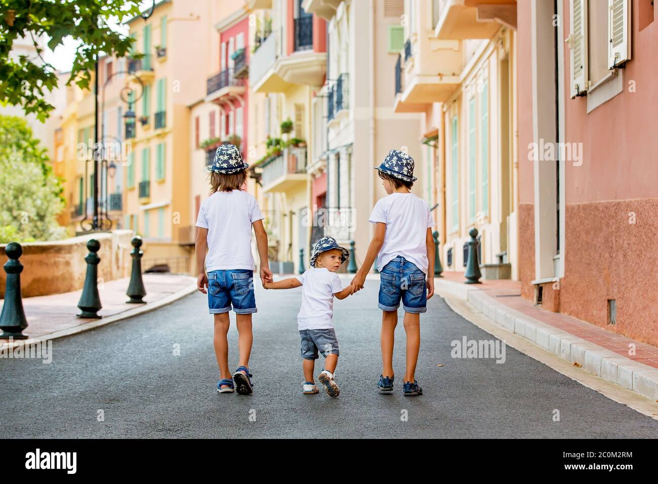 Children walking on a narrow street with houses in Monaco-Ville, Monaco ...