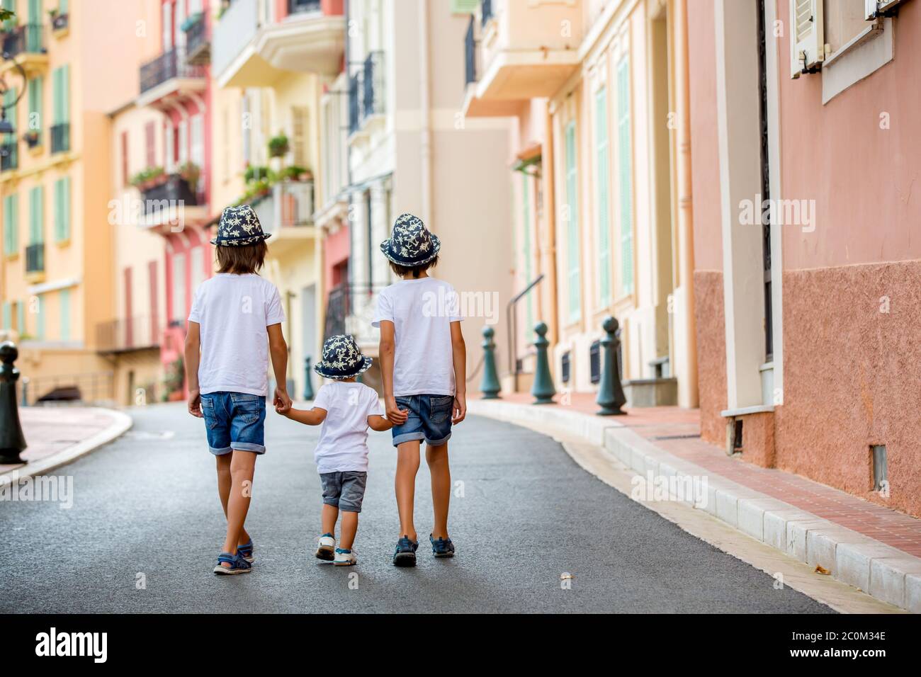 Children walking on a narrow street with houses in Monaco-Ville, Monaco ...