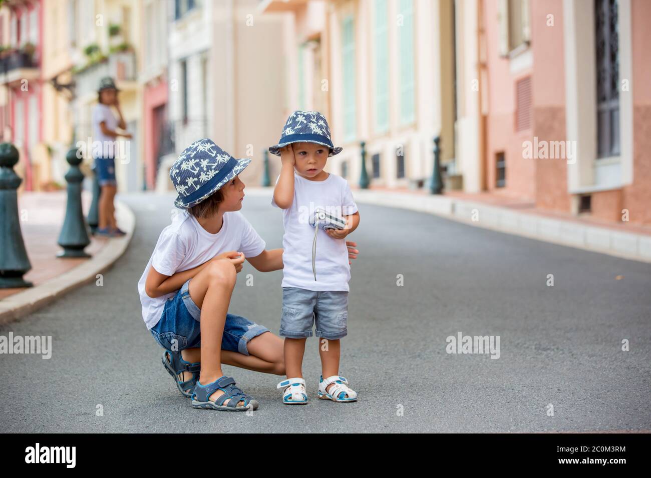 Children taking pictures on a narrow street with houses in Monaco-Ville ...