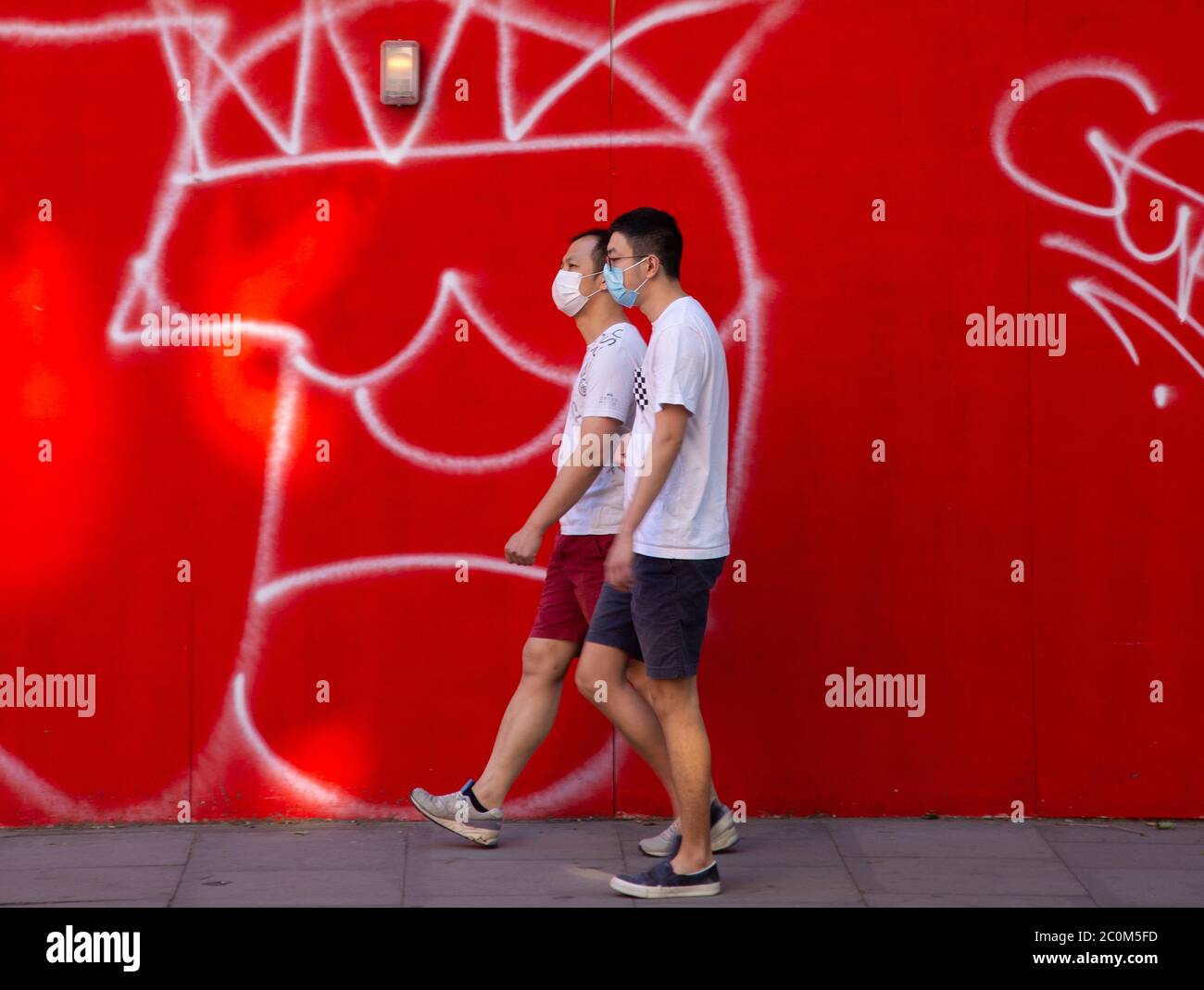 2 pedestrians walking wearing face masks during the Covid 19 crisis ...