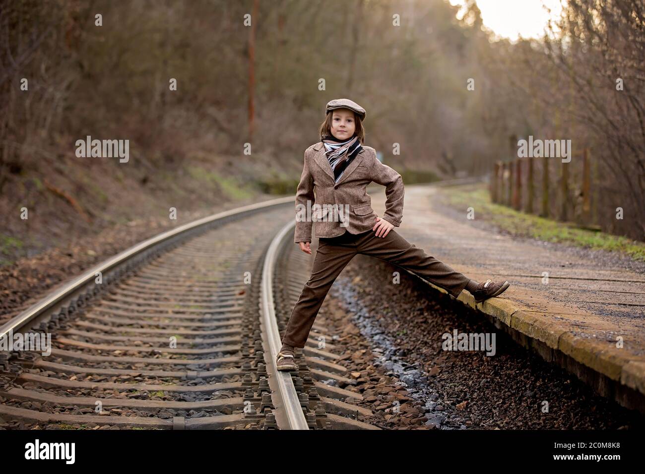 Adorable boy on a railway station, waiting for the train, running and ...