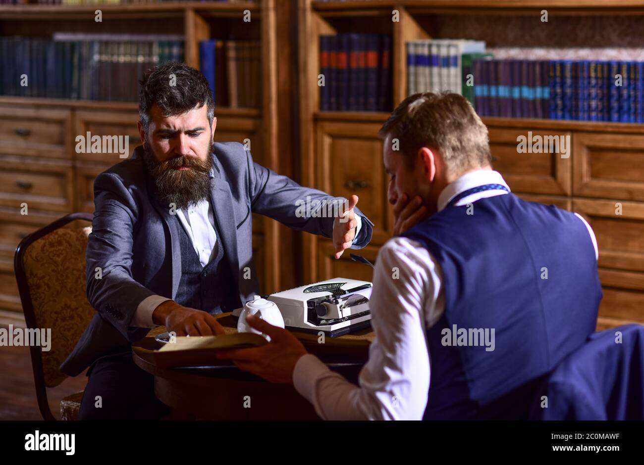 Man with beard interviews writer. Man in suit or journalist with friend ...