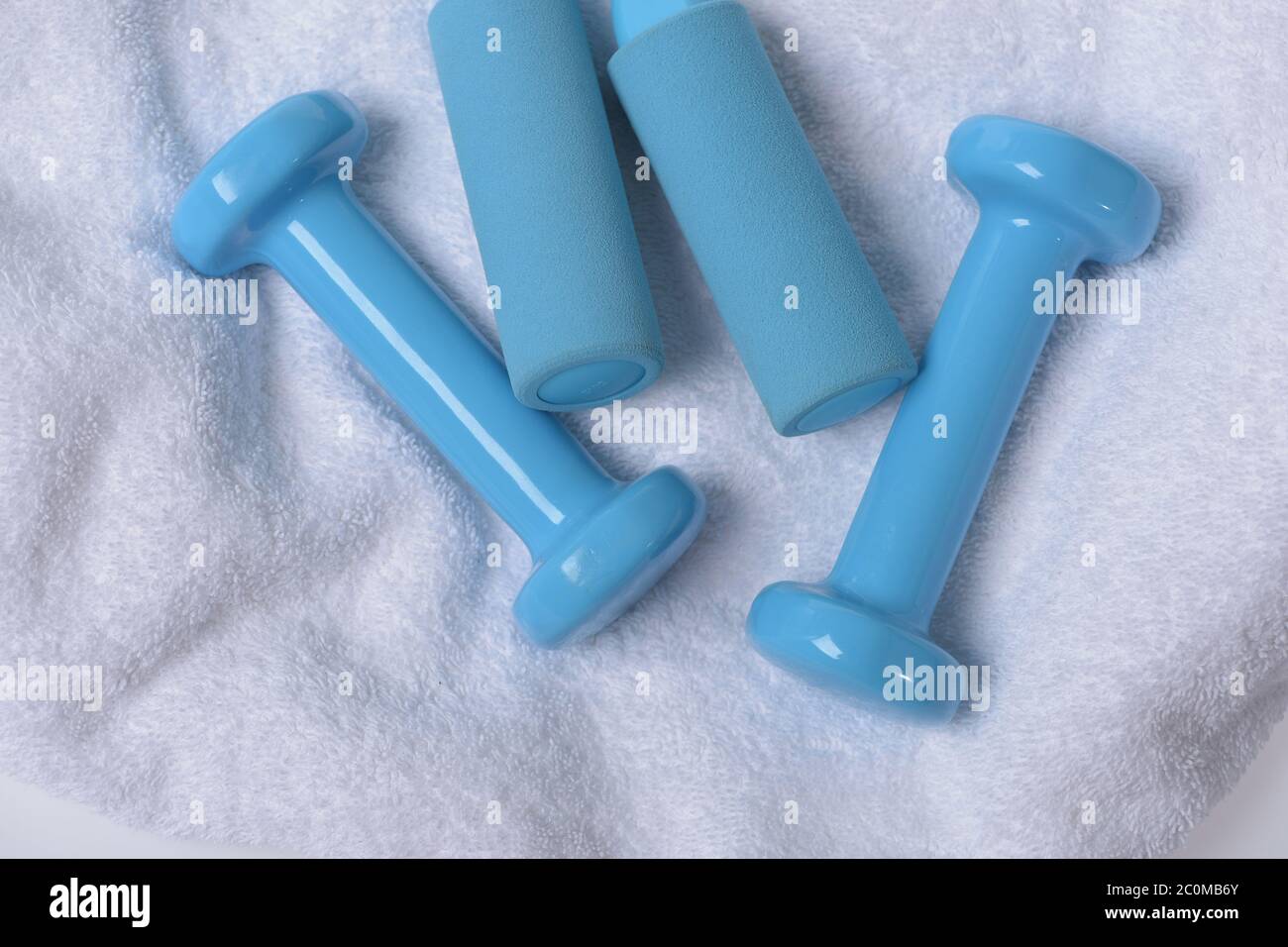 Jump rope handles and barbells placed next to each other. Fit shape and ...