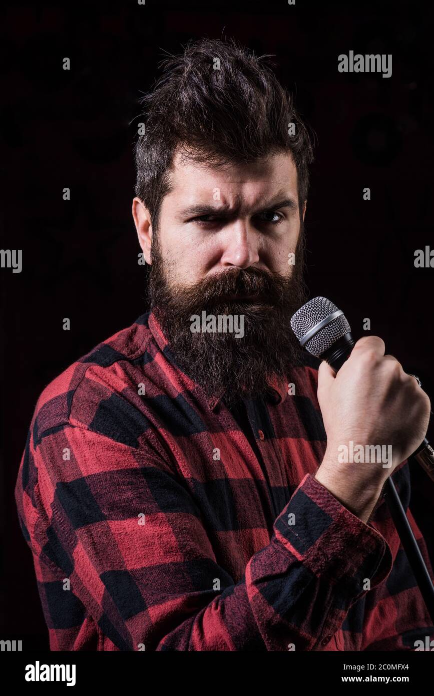 Portrait of pensive, thoughtful young male singer holding microphone ...