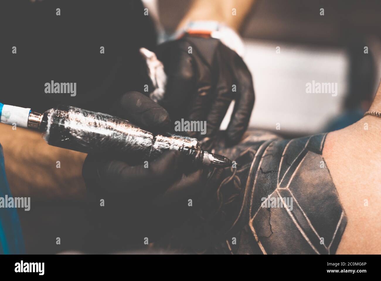 Tattoo salon. The tattoo master is tattooing a man on his shoulder ...