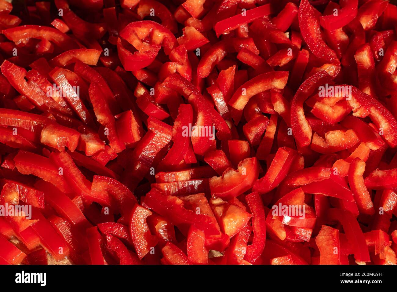 Small cut slices of red pepper for red background Stock Photo - Alamy