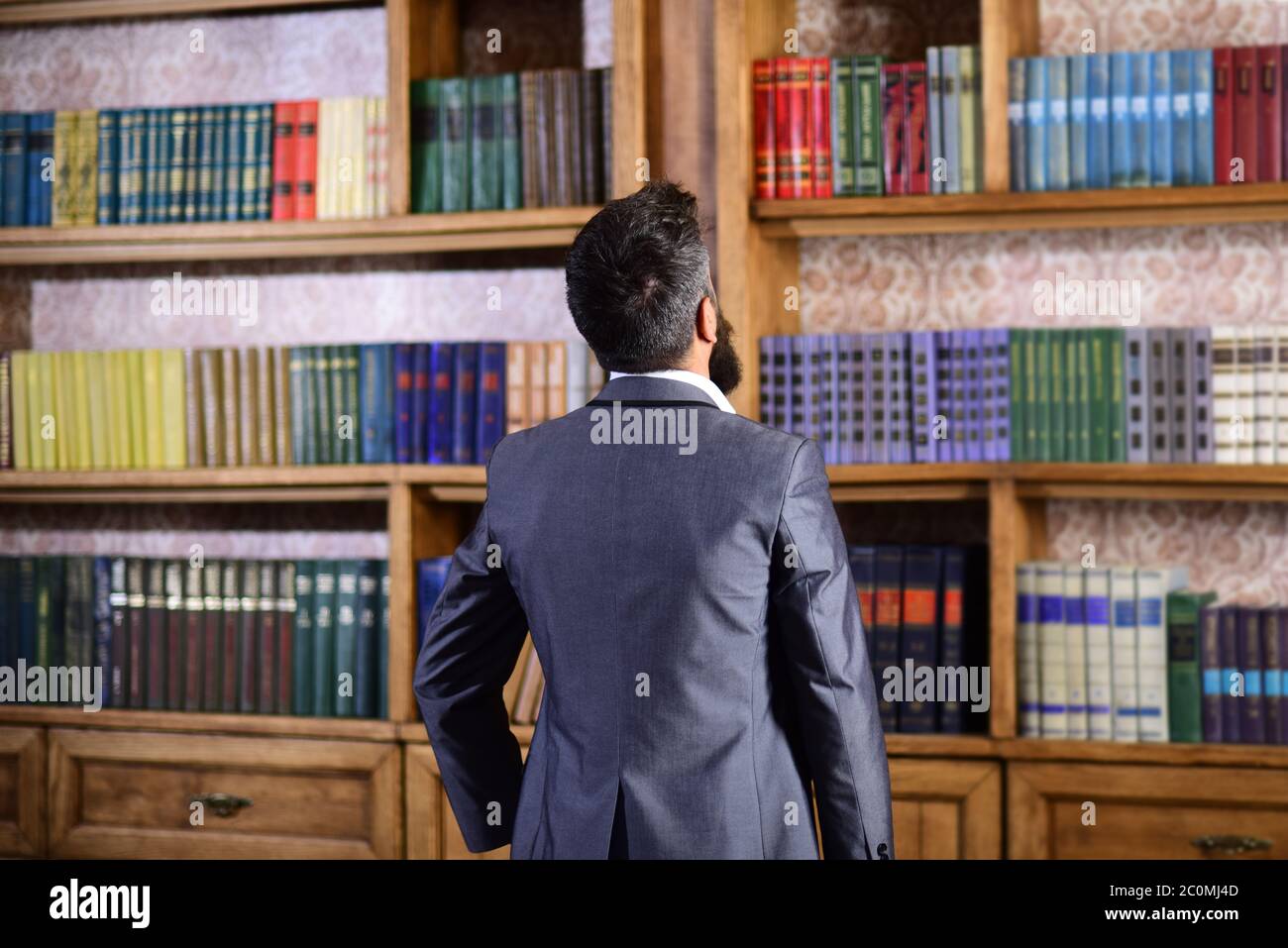 Library books concept. Man in formal wear looks at library books Stock ...