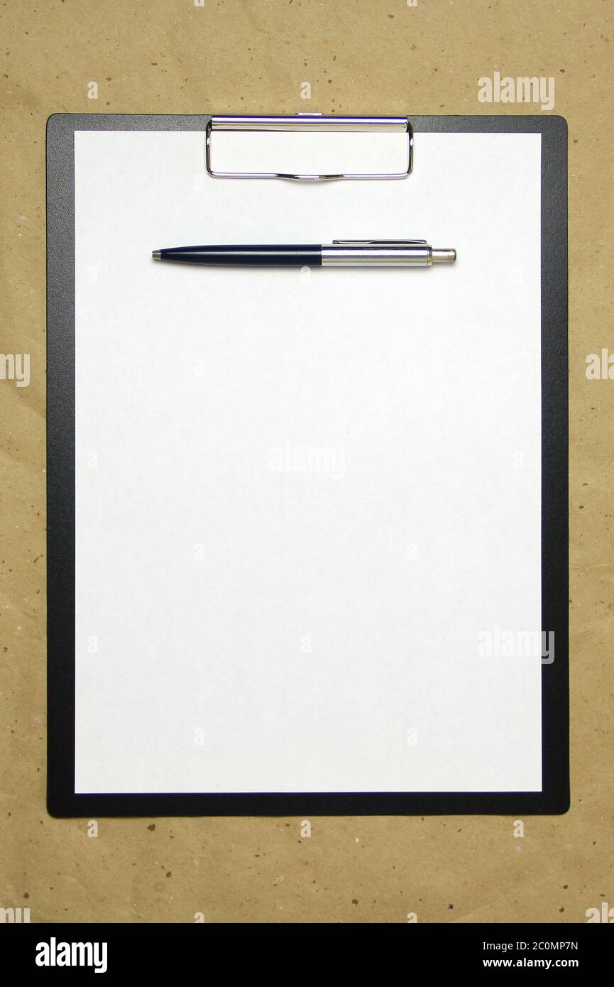 A tablet with a white sheet of A4 format with pen on a beige craft ...