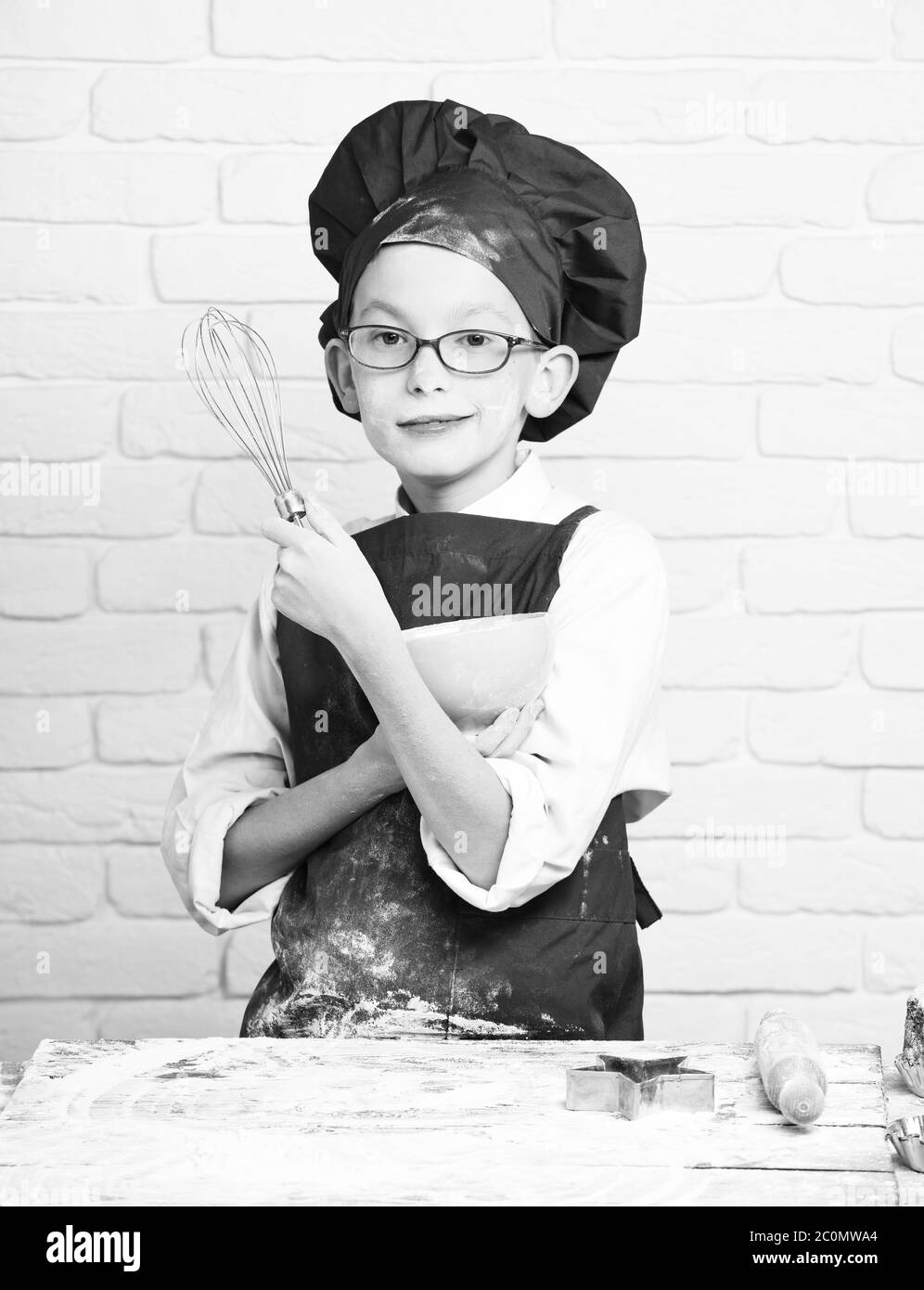 young boy cute cook chef in red uniform and hat on stained face flour ...
