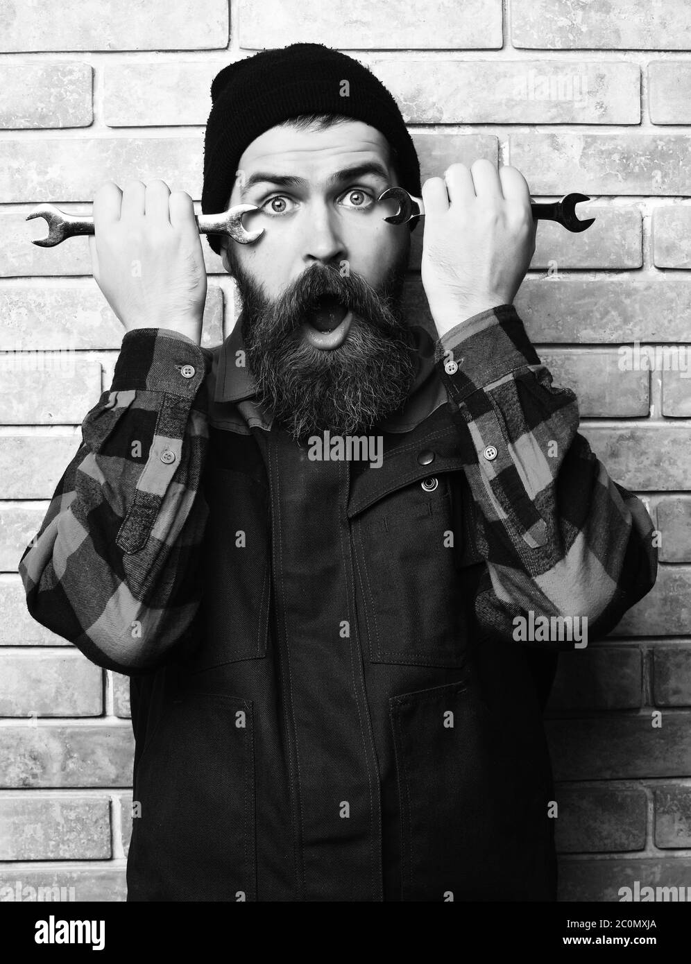 Bearded man, long beard. Brutal caucasian mechanic, surprised unshaven ...