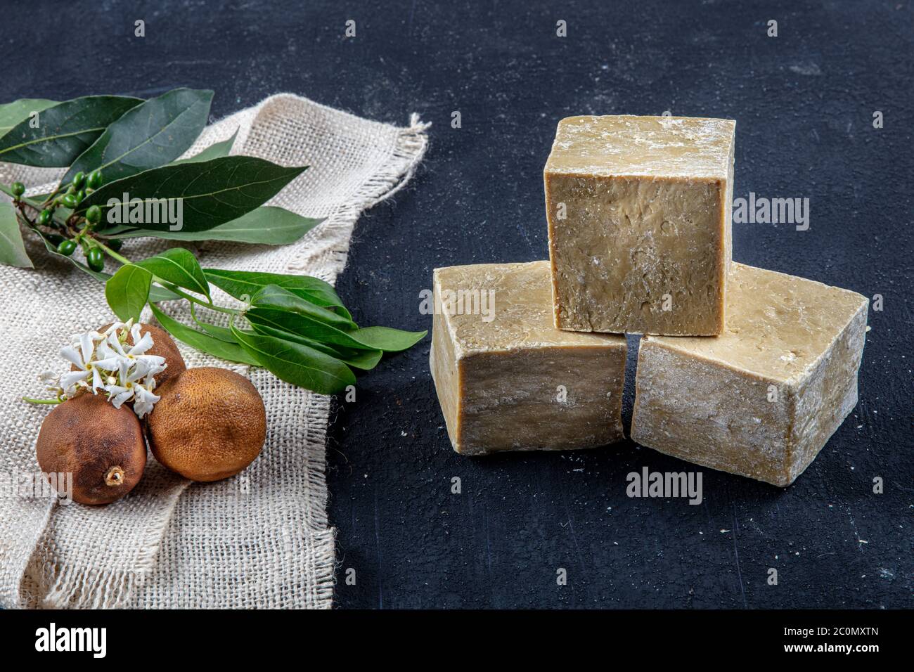 Natural handmade soap and bay leaves (laurel) on black wood background ...
