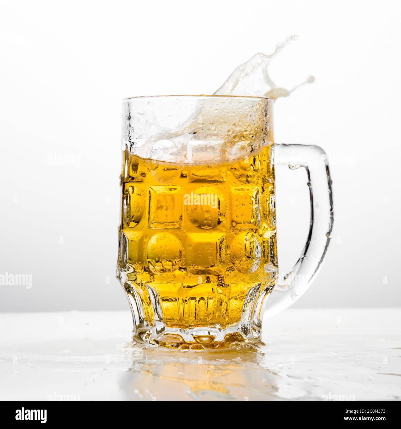 Beer splashing in glasses on white Stock Photo - Alamy