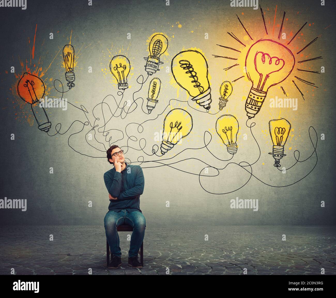 Thoughtful businessman, hand under chin, sitting on a chair, looking at ...