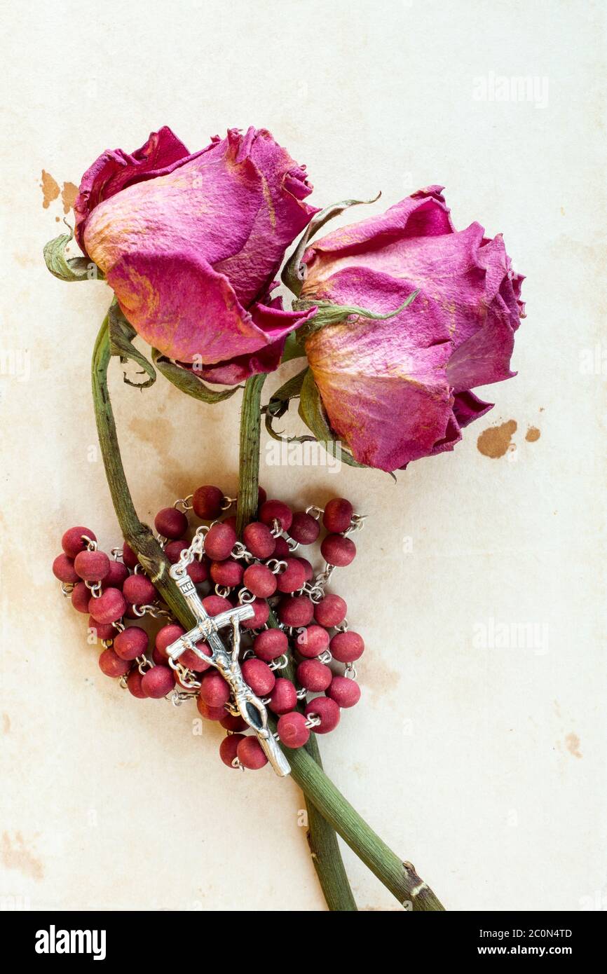 Two dried roses and rosary Stock Photo - Alamy