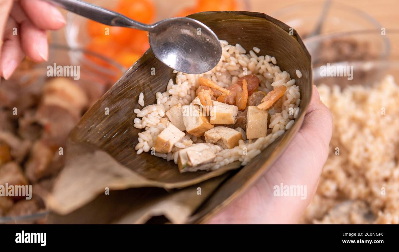 Making Rice dumpling - wrapping Chinese zongzi food on table at home ...