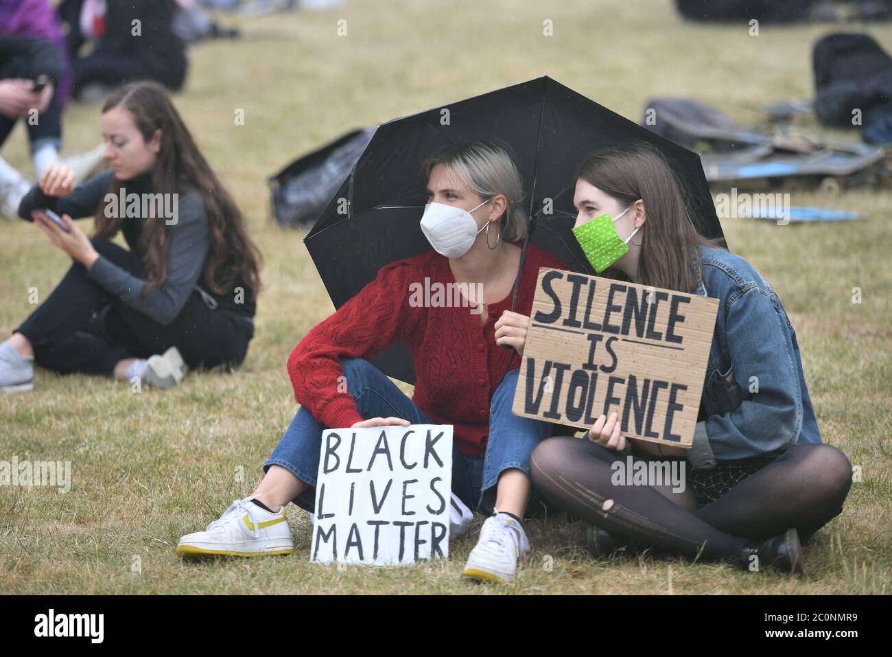 Protesters shelter from the rain at a Black Lives Matter protest rally ...