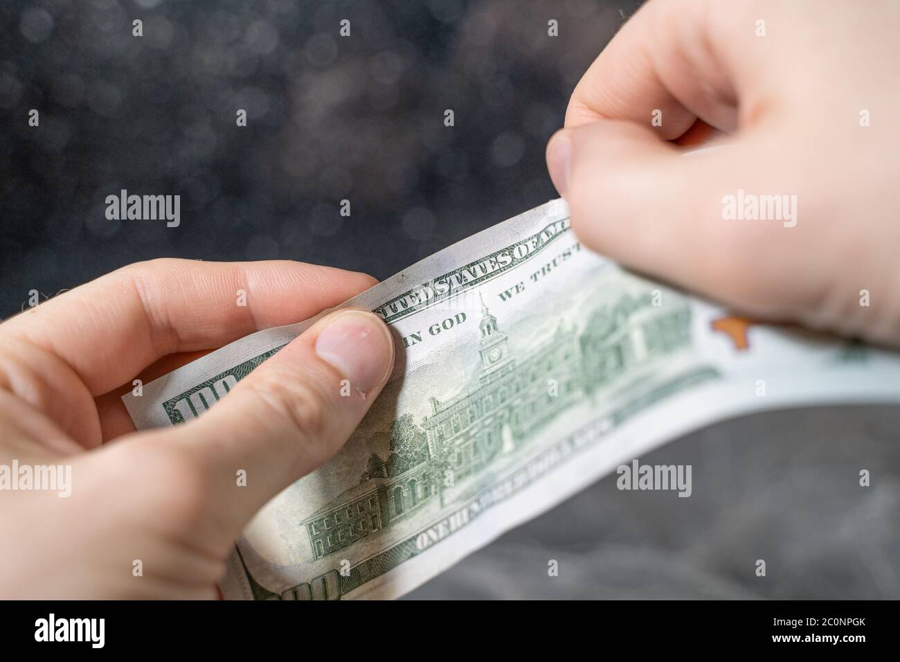 white man hands tear dollars Stock Photo - Alamy