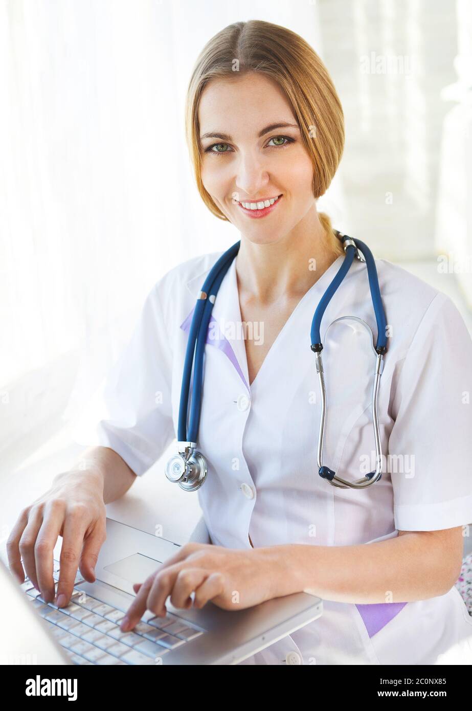 Portrait of young woman doctor at computer Stock Photo - Alamy