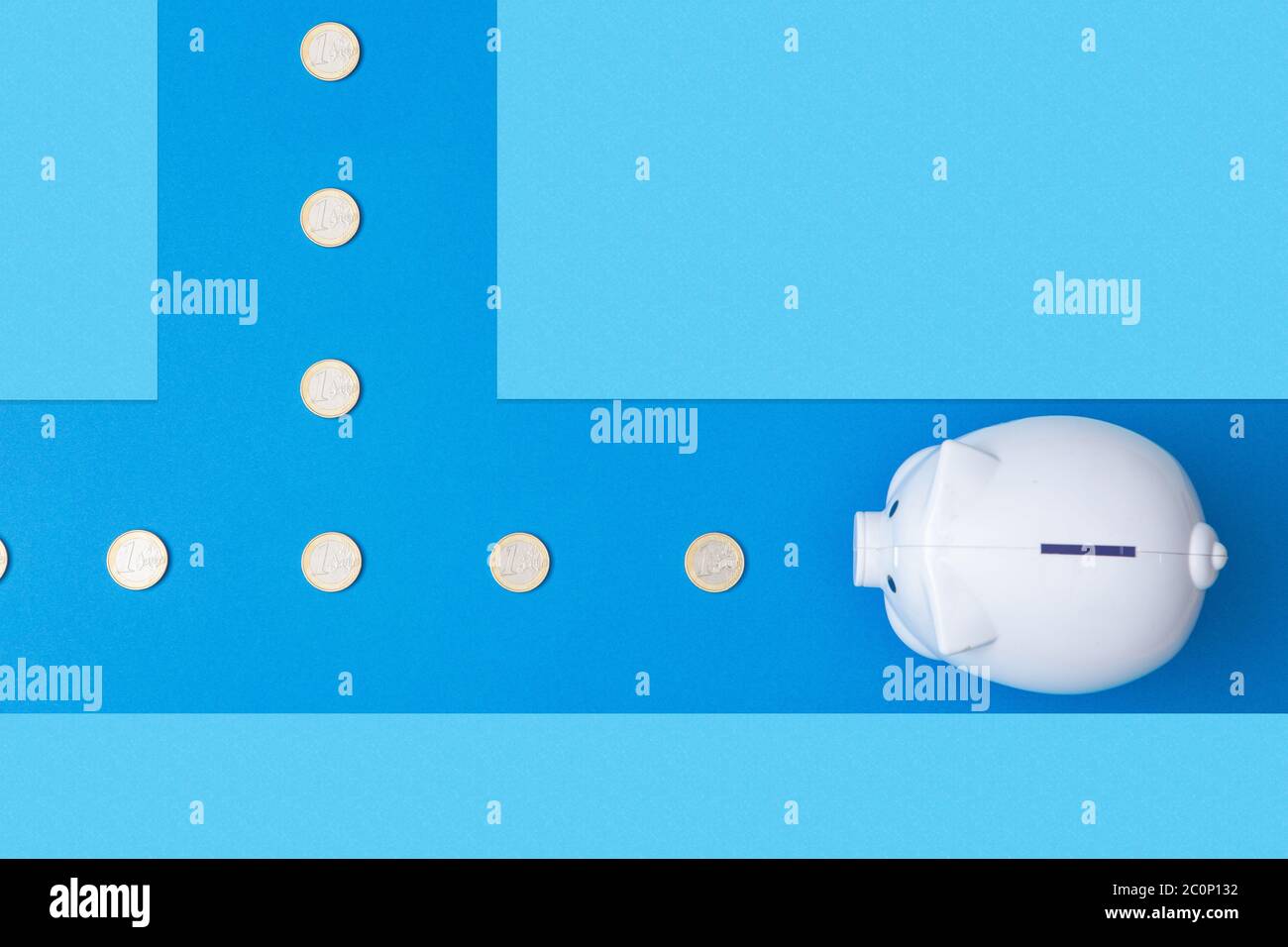 White piggy bank eating euro coins, simulating a video game on a blue ...