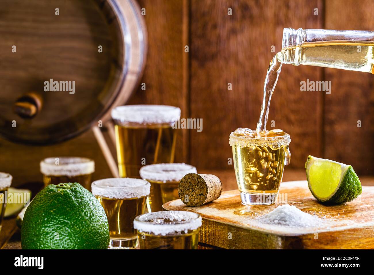 tequila bottle filling glass of drink. Typical mexican drink being ...