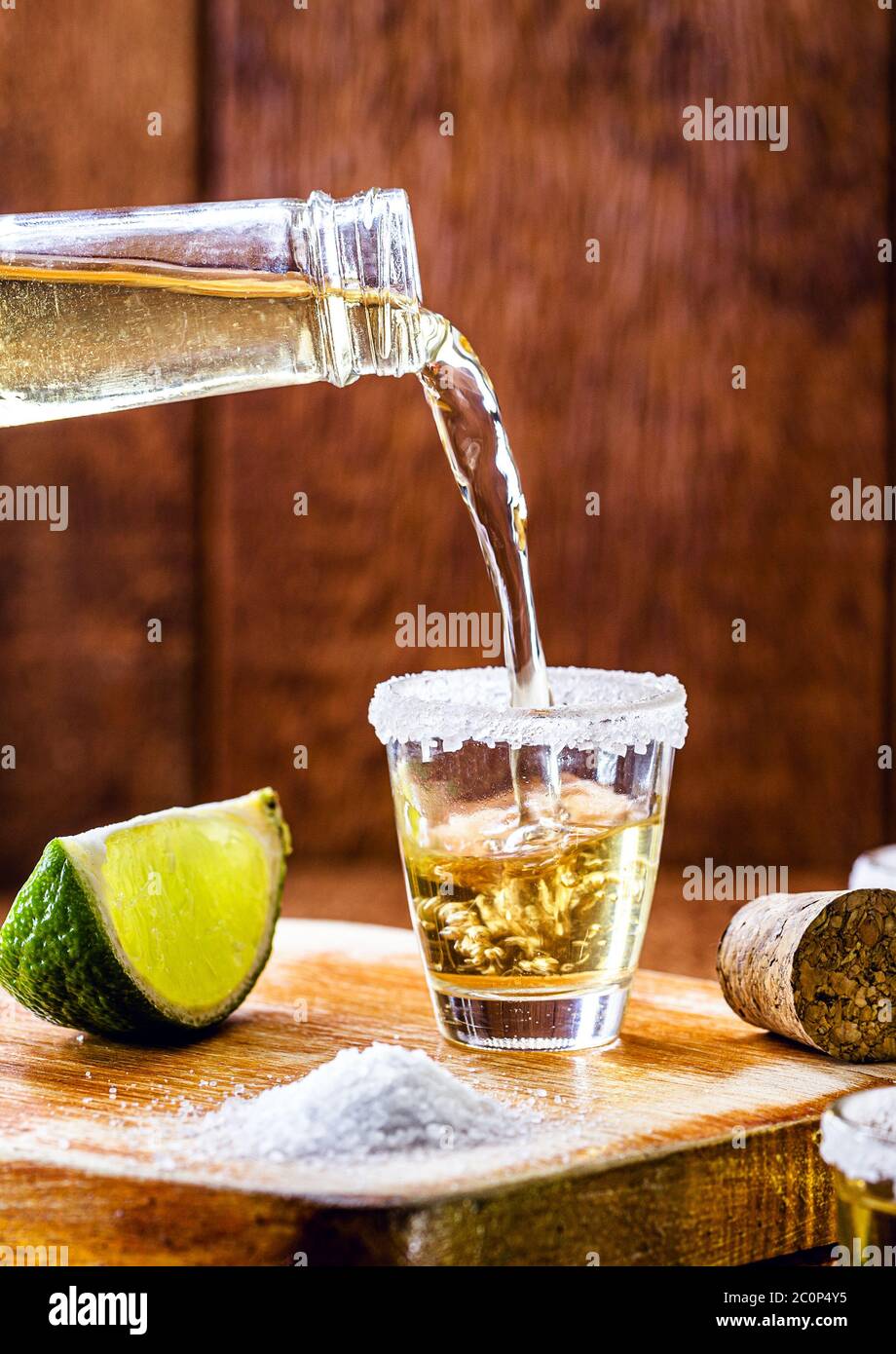 tequila bottle filling glass of drink. Typical mexican drink being ...