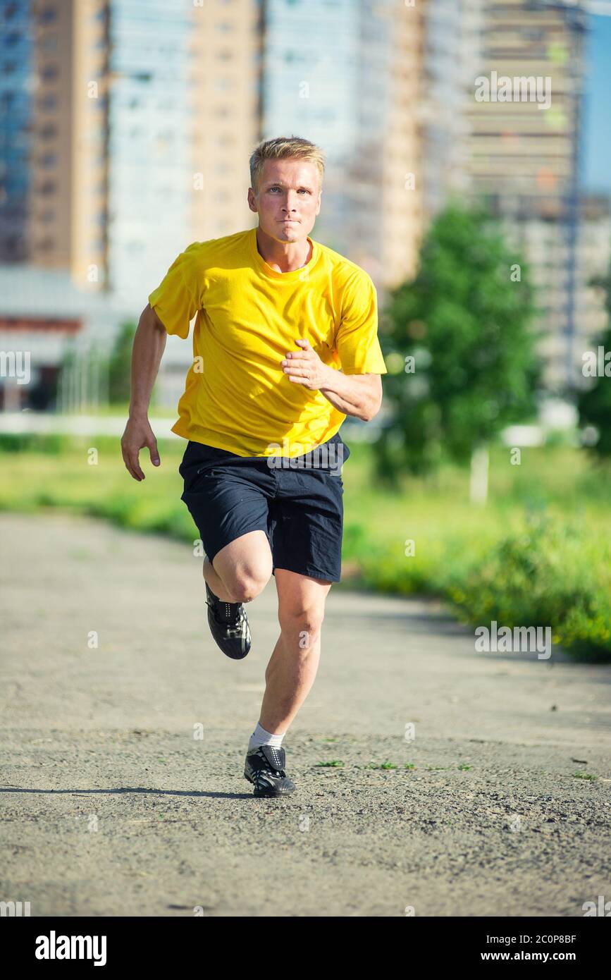 Sporty man jogging in city street park. Outdoor fitness Stock Photo - Alamy