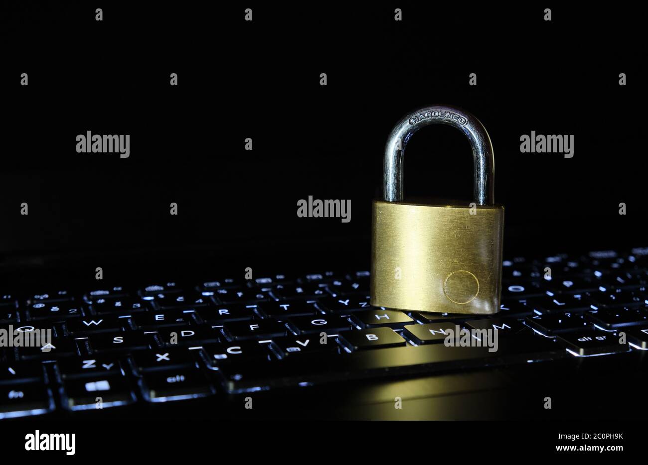 Padlock made of hardened steel on backlit laptop keyboard. Security and ...