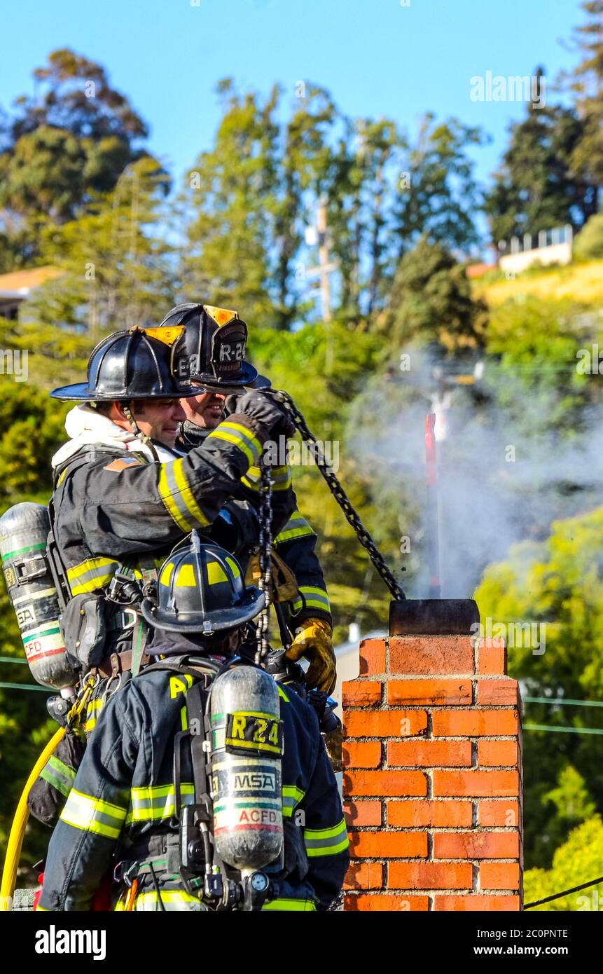 Alameda County fire department workers extinguish a chimney fire in San ...